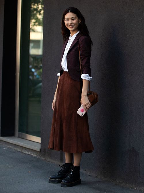 Model Ho Yeon Jung in einer weißen Bluse zu einem dunkelroten Blazer und einem roten Midirock.