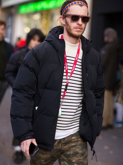 Streetstyle mit einer schwazen Daunenjacke, einem Ringelpullover und einer Sonnenbrille.