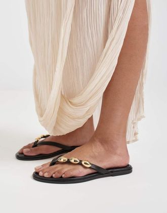 Dolce Vita Juny - Sandales &agrave; entre-doigts en cuir &agrave; d&eacute;tails dor&eacute;s - Noir