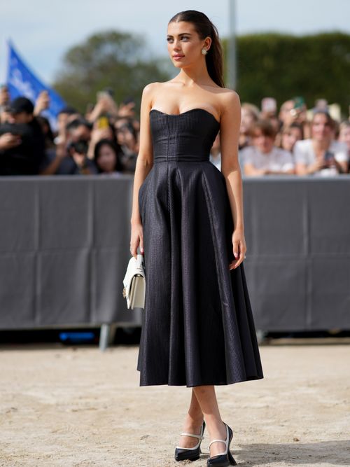 Amelie Zilber trägt ein schwarzes Bandeau-Kleid in Midilänge mit Mary-Janes Pumps und weißer Tasche auf der Paris Fashion Week.