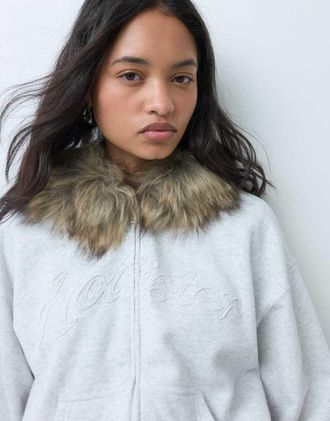 Hollister Kapuzenjacke mit Rei&szlig;verschluss, Logo-Print und faux-fur-Besatz in Hellgrau