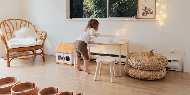 Mädchen vor einem kleinen Kindertisch aus Holz.