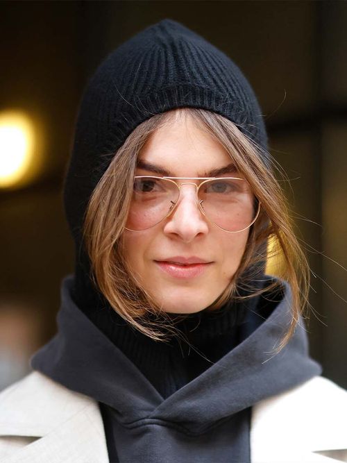 Streetstyle mit einer schwarzen Mütze, einem Kapuzensweater und einer Pilotenbrille.