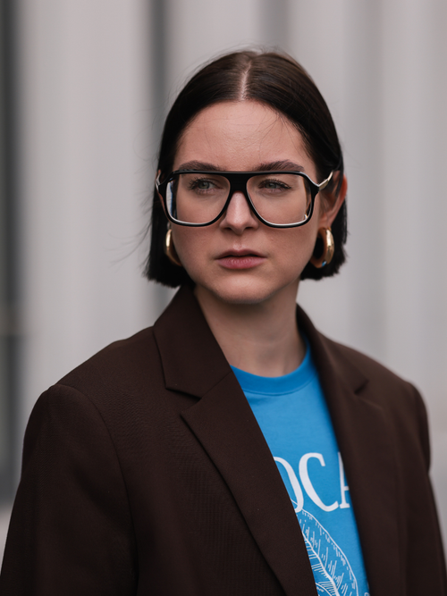 Maria Barteczko trägt eine optische Brille von Victoria Beckham mit einem Blazer und blauem T-Shirt in Düsseldorf.