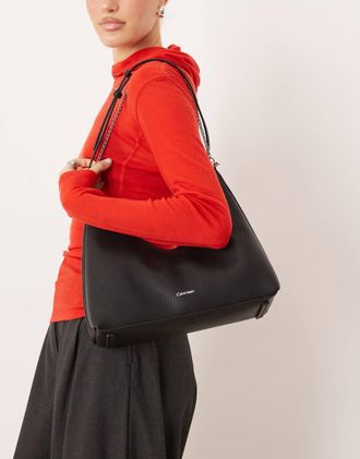 Calvin Klein Schultertasche in Schwarz mit genarbter Struktur, Rei&szlig;verschluss oben und silberfarbenem Kettenriemen