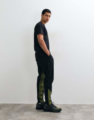 New Balance Utility Stretch-Woven-Hose in Schwarz und Sportgr&uuml;n