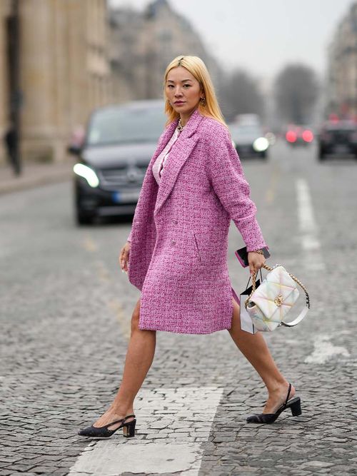Streetstyle mit einem rosanen Bouclemantel und einer weißen Chanel-Tasche.