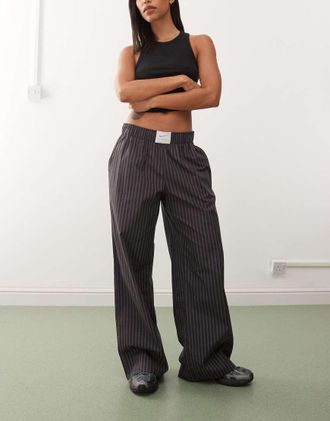 Nike Gestreifte Popeline-Hose in Schwarz und Grau mit weitem Bein-Rot