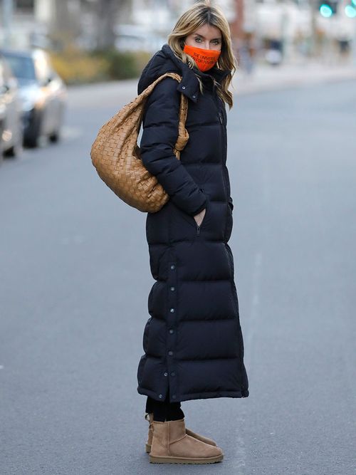 Gitta Banko mit einem schwarzen Daunenmantel und brauen UGG-Boots.