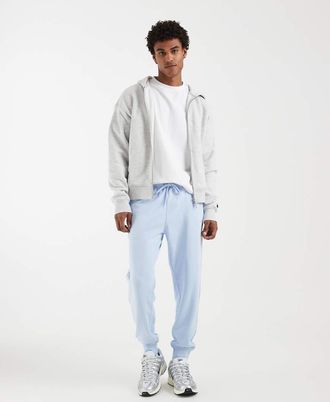 Nike Club - Pantalon de jogging en tissu duveteux resserr&eacute; aux chevilles - Bleu clair