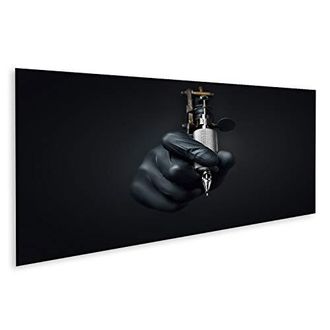 Islandburner Tableau Tableaux sur toile Tatoueur tenant une machine &agrave; tatouer sur fond fonc&eacute;, Machine pour un concept de tatouage Impression Image Motif moderne D&eacute;