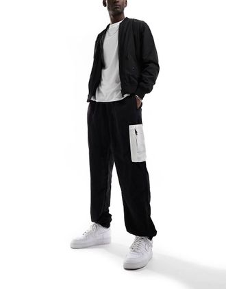 The North Face Pantalon de jogging ample tiss&eacute; en nylon - Noir et blanc