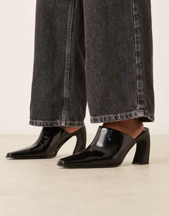 Raid Hania - Mules in Schwarz mit gebogenem Absatz und spitzer Zehenpartie