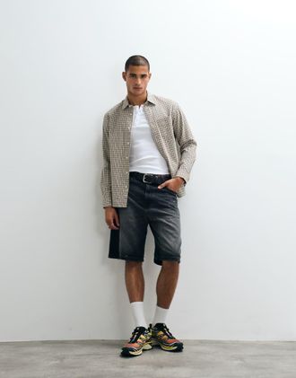 Carhartt Work in Progress Landon - Shorts in schwarzer Used-Waschung mit Farbspritzer-Effekt