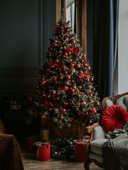 Christbaum mit roten Kugeln und Schleifen.