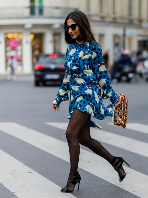 Influencerin Nausheen Shah trägt ein blaues Kleid und blickdichte Strümpfe mit zarten Punkten