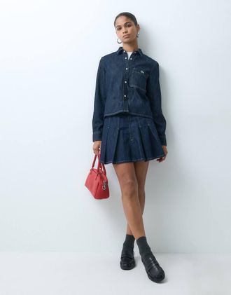 Lacoste ensemble coordonn&eacute; jupe courte pliss&eacute;e en jean bleu d&eacute;lavage moyen