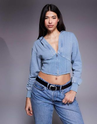 Good American Cropped-Kapuzenpullover aus Baumwolle in hellblauer Waschung mit Korsettdetail
