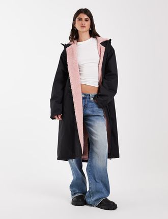 Asos manteau long imperm&eacute;able noir avec doublure en imitation peau de mouton rose