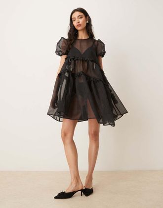 Ghospell Exclusivit&eacute; - Ghospell - Robe courte en organza transparent &agrave; manches bouffantes, volants &eacute;tag&eacute;s et ourlet asym&eacute;trique - Noir