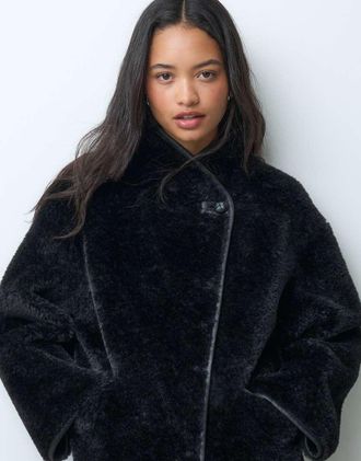 Arket Oversize-Jacke aus Kunst-Shearling mit Stehkragen und Kontrastkante in Schwarz