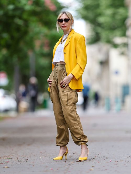 Blonde Frau kombiniert beige Cargohose mit gelbem Blazer und weißem Tshirt