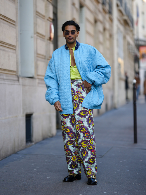 Rahi Chadda trägt eine hellblaue Steppjacke mit einem gelben T-Shirt und bunter Hose auf der Paris Fashion Week.