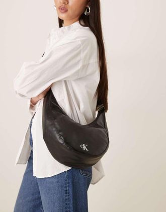 Calvin Klein Gl&auml;nzende, umwandelbare Moon-Tasche in Schwarz mit Schnalle