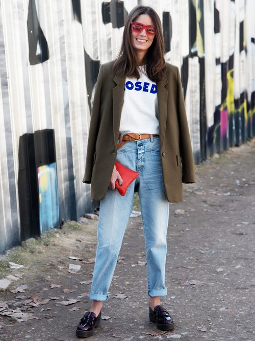 Chloe Sachdev associe son denim à un T-shirt à message et une veste de blazer vert olive. Le look est rehaussé par une paire de derbies compensées. 