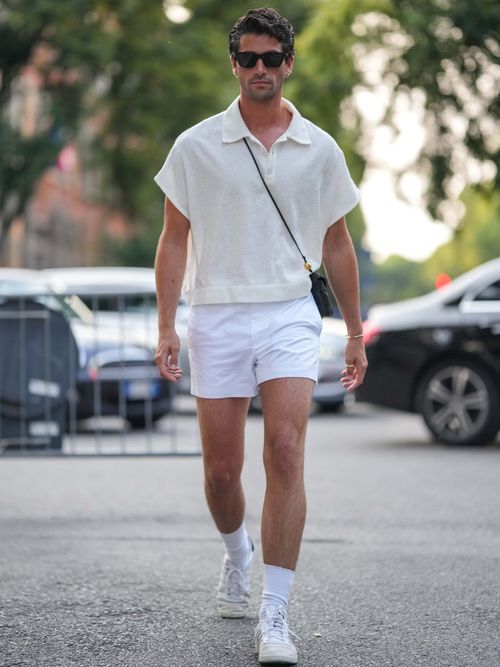 Marc Forne trägt ein beiges Poloshirt, weiße Shorts und weiße Sneakers, mit Sonnenbrille auf der Milan Fashion Week.