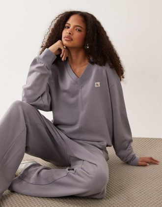 Calvin Klein Jeans Woven Label French Terry lang&auml;rmliges Sweatshirt mit V-Ausschnitt in Fliedergrau-Silber