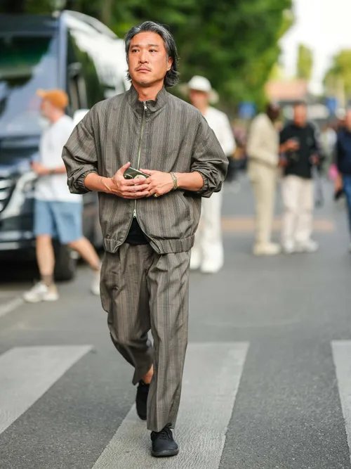 Street Style Look von der Milan Fashion Week, wo ein Gast eine grau-gestreifte Kombi trägt.