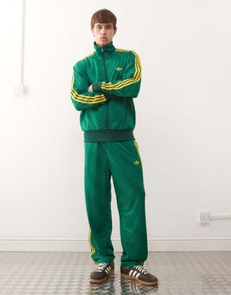adidas Originals Firebird - Lockere Trainingshose in Collegiate Gr&uuml;n mit Monogramm-Muster