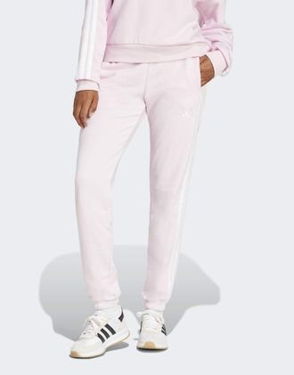 adidas Essentials - Hose aus French Terry in klarem Rosa / Wei&szlig; mit den drei Streifen und B&uuml;ndchen