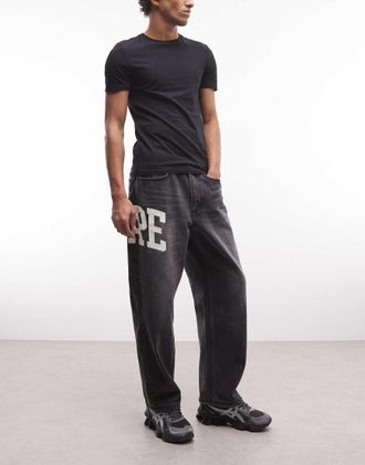 Aape By A Bathing Ape AAPE by A BATHING APE - Loose-Fit-Jeans aus Denim in verwaschenem Schwarz mit Logoprint