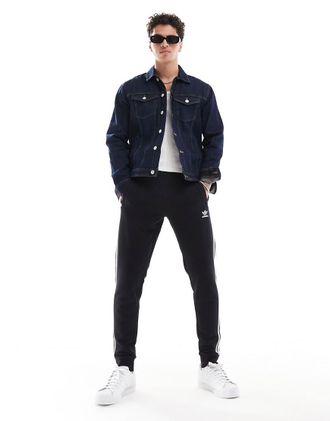 adidas Originals Schwarze Jogginghose mit drei Streifendesign