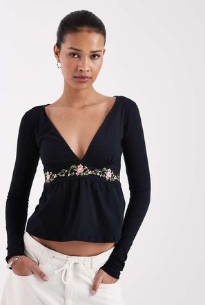 Motel Yahop - Lang&auml;rmliges Oberteil in Schwarz mit tiefem Ausschnitt und Blumendetail