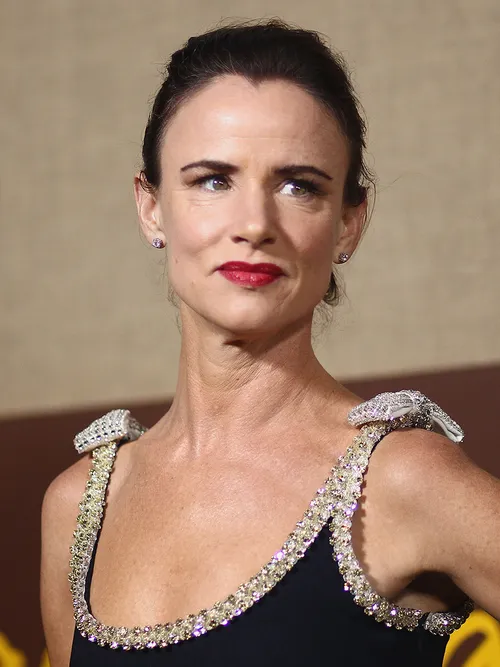 Juliette Lewis in einem Kleid mit Schleifen an den Schultern und roten Lippen.