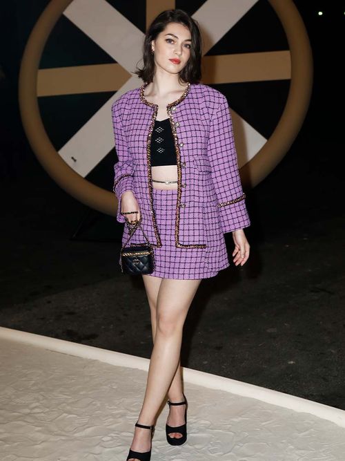 Ein Look aus einem lila Chanel-Kostüm und schwarzen Plateau-Schuhen.